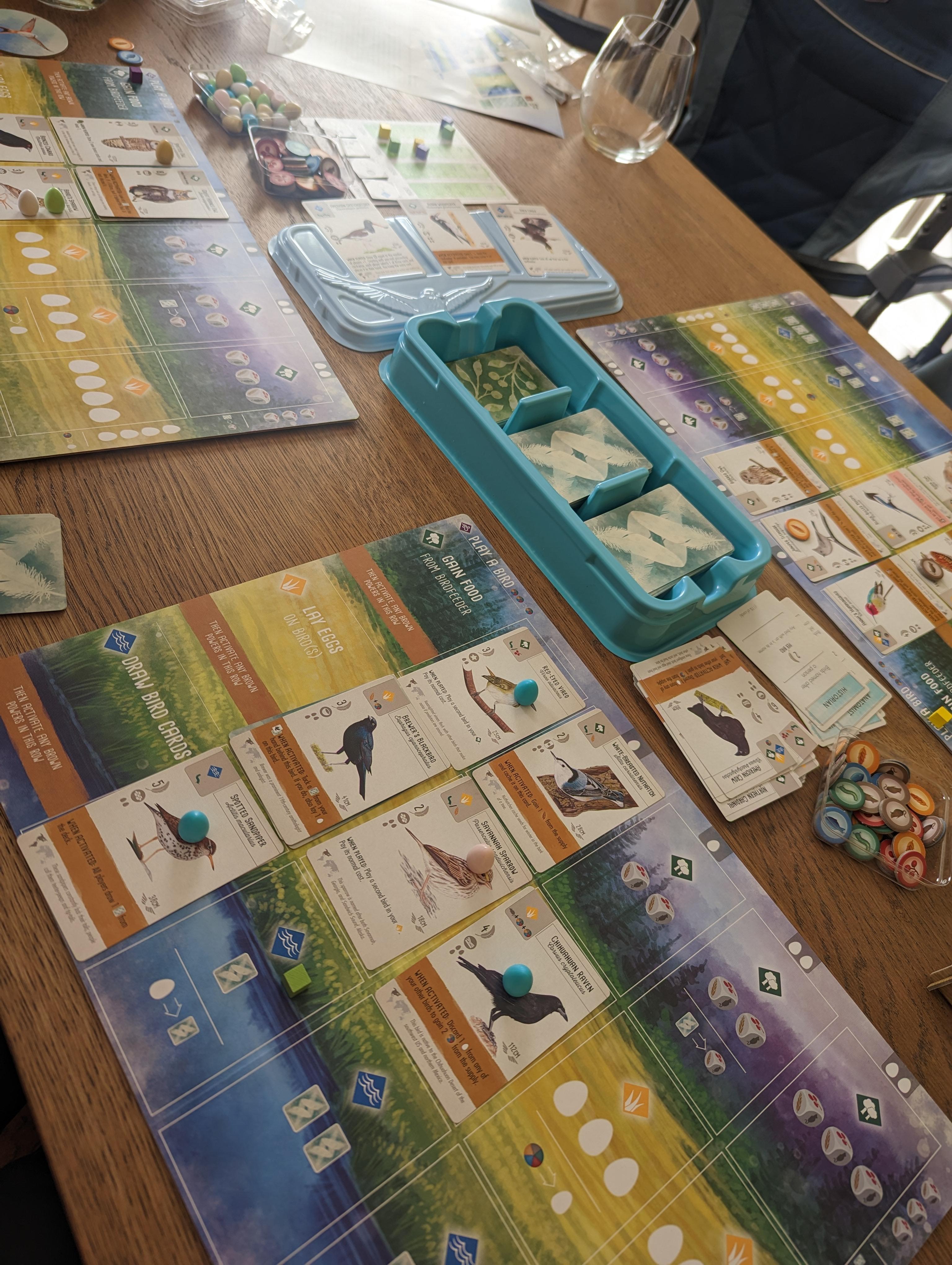 Table with the board game Wingspan being played