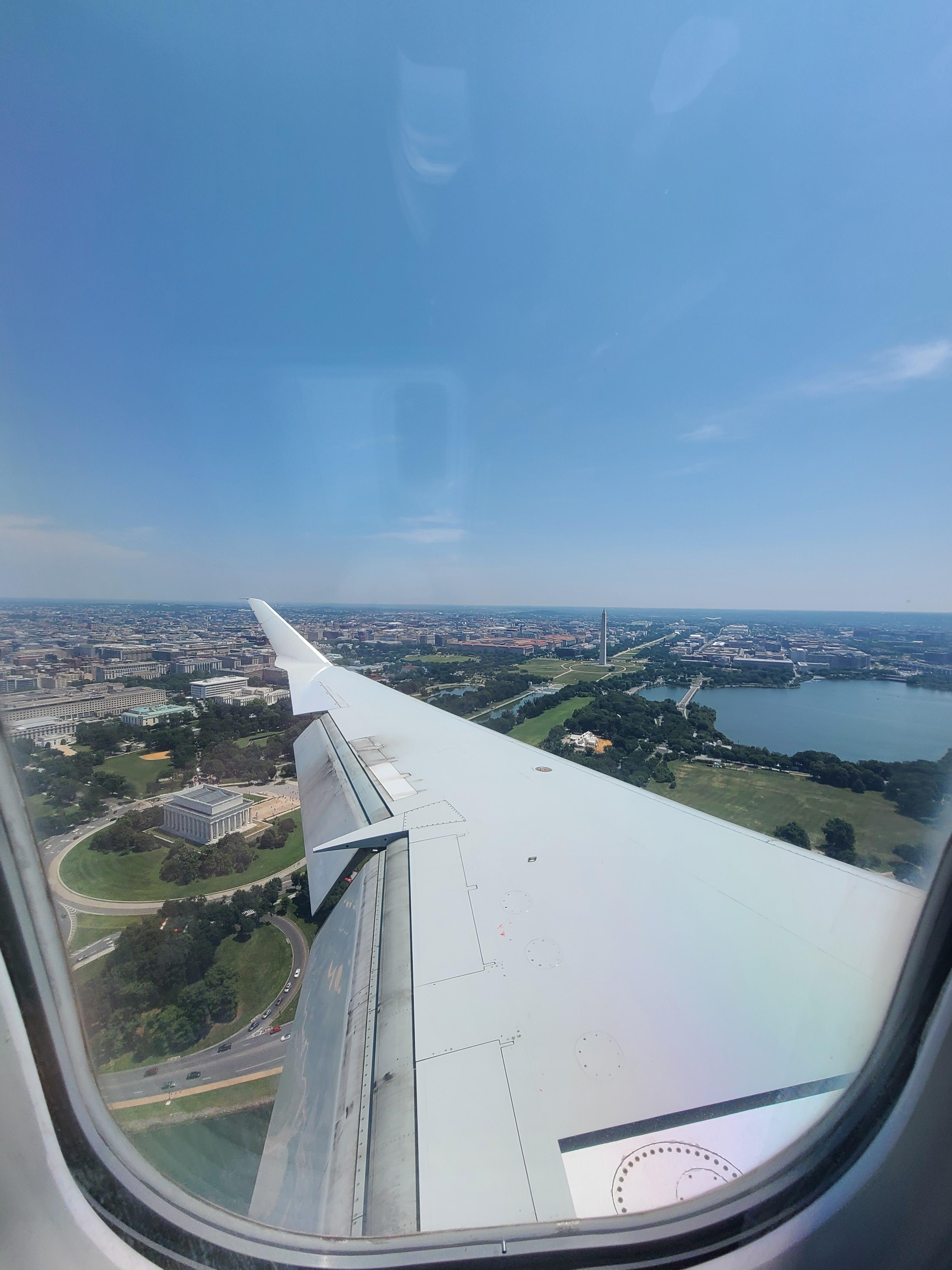 Plane window with a plane wing and Washington D.C. in the background
